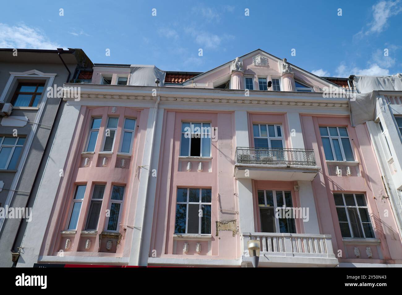 Historic pink architectural facade in a bustling city reveals intricate ...