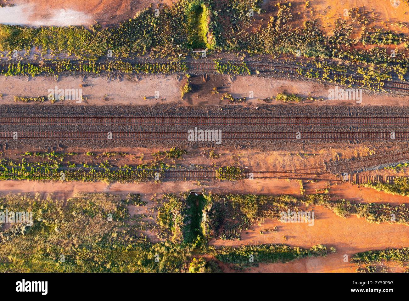 Aerial view of railway tracks running through a red outback landscape ...