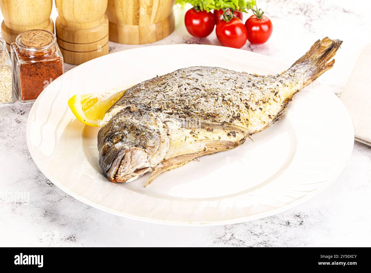 Baked Dorado fish served lemon slice Stock Photo - Alamy