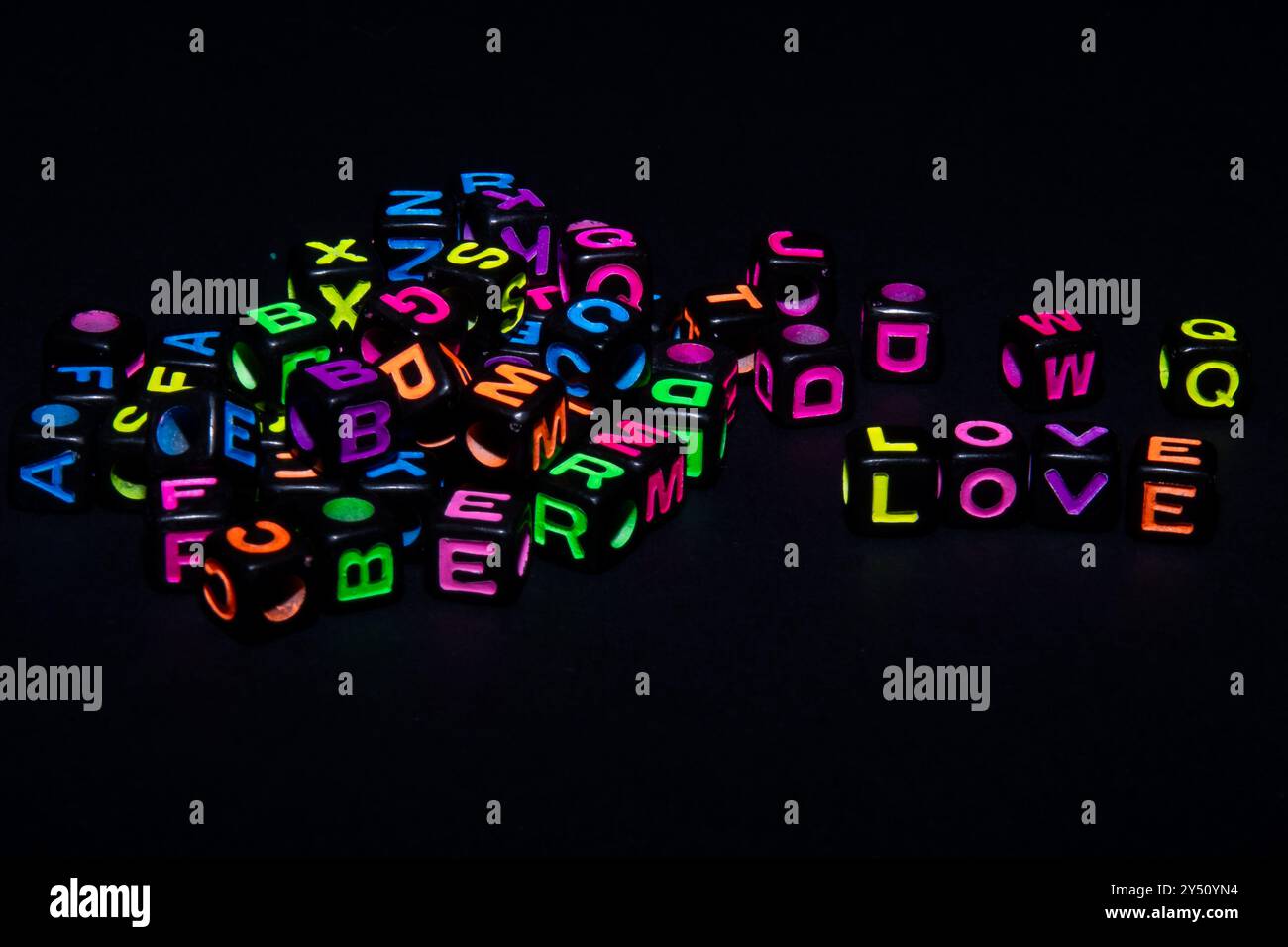 A collection of alphabet beads glowing in the dark, arranged in a neat ...