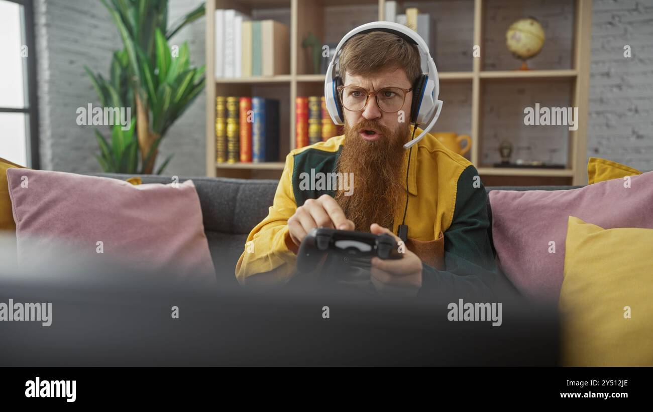 Bearded man with glasses and headphones intensely playing video games ...