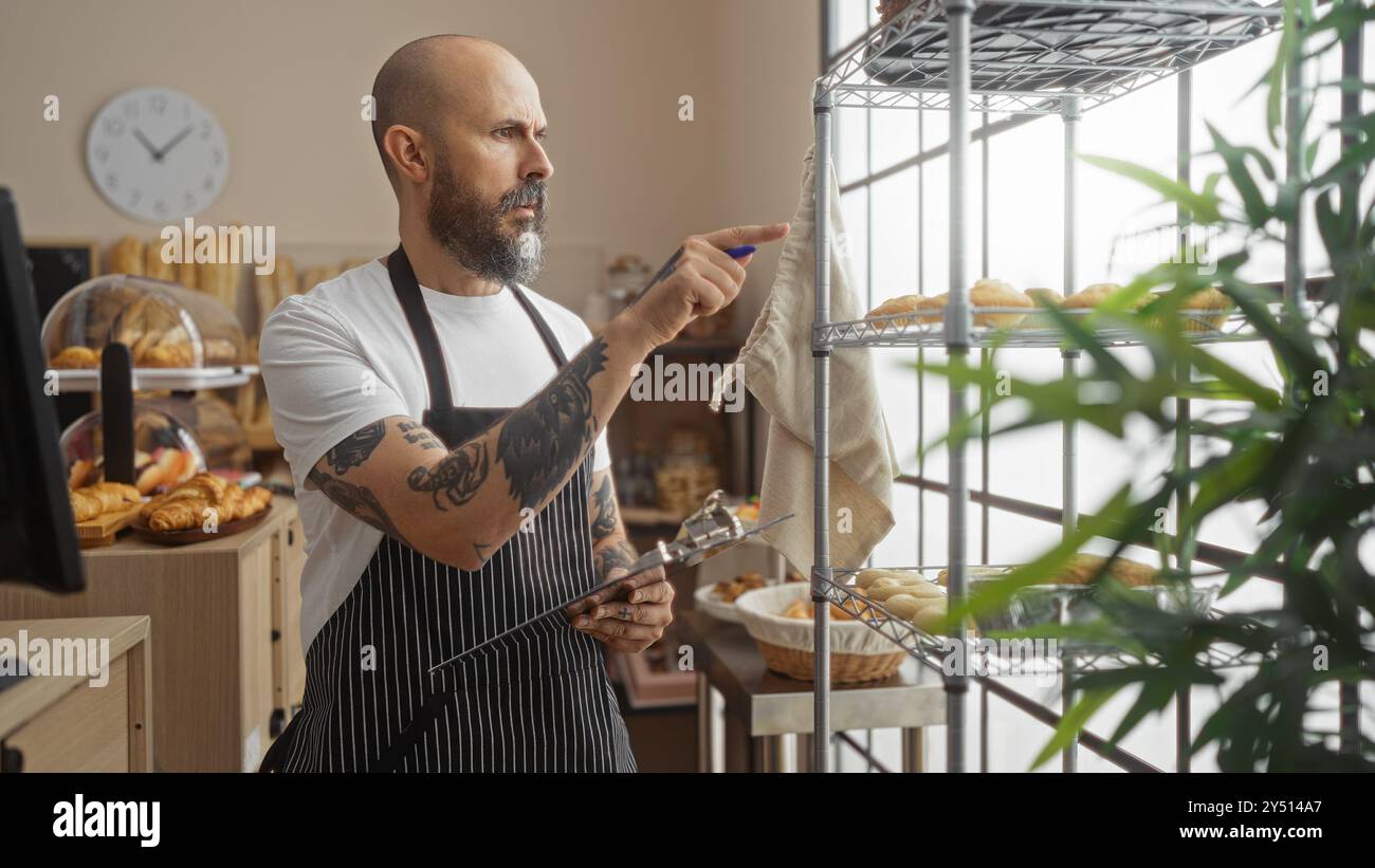 Bearded man sorting baked goods in a bakery interior, pointing at bread ...