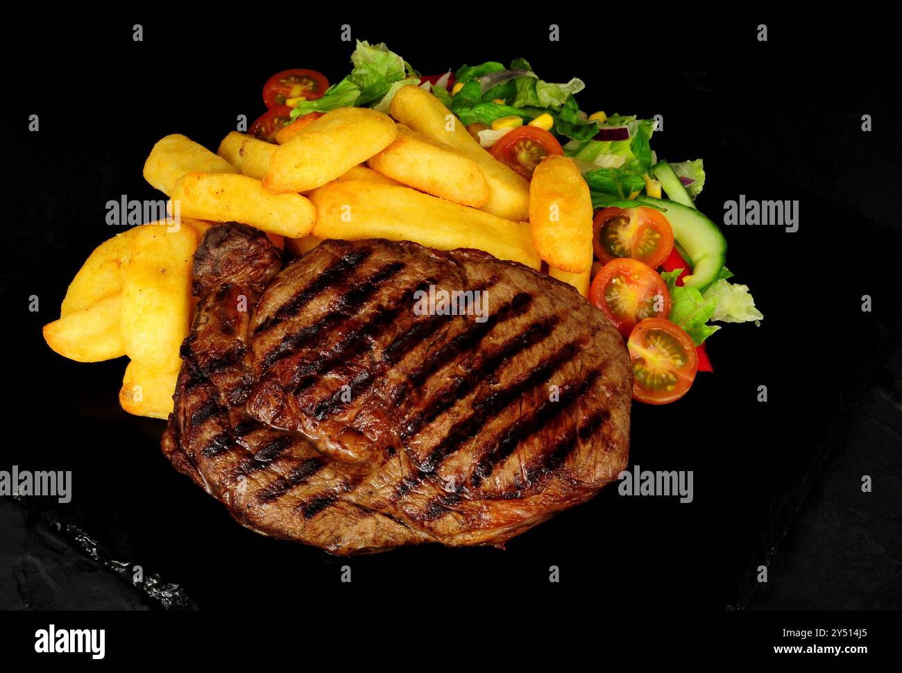 Grilled rib eye beef steak meal with chunky chips and salad Stock Photo ...