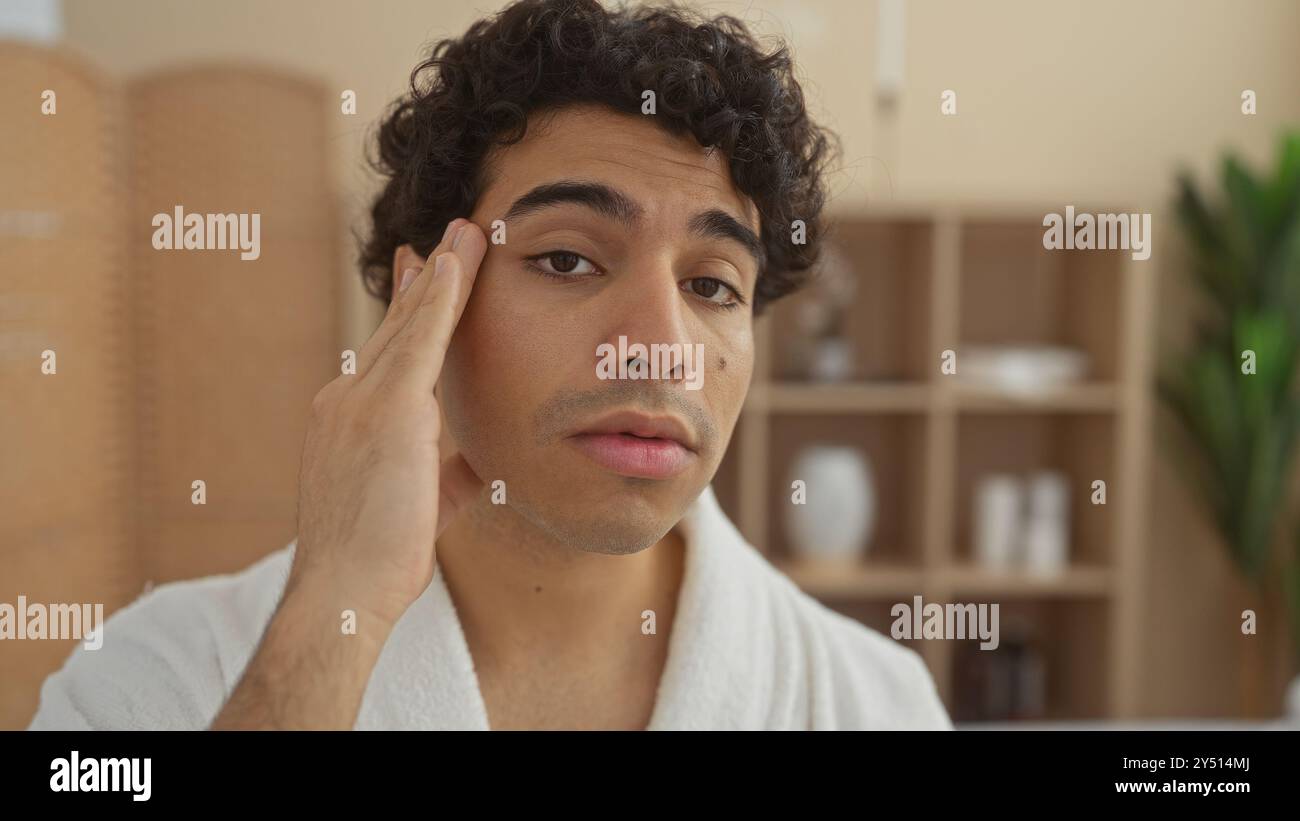 A handsome young hispanic man in a wellness spa's interior, touching ...