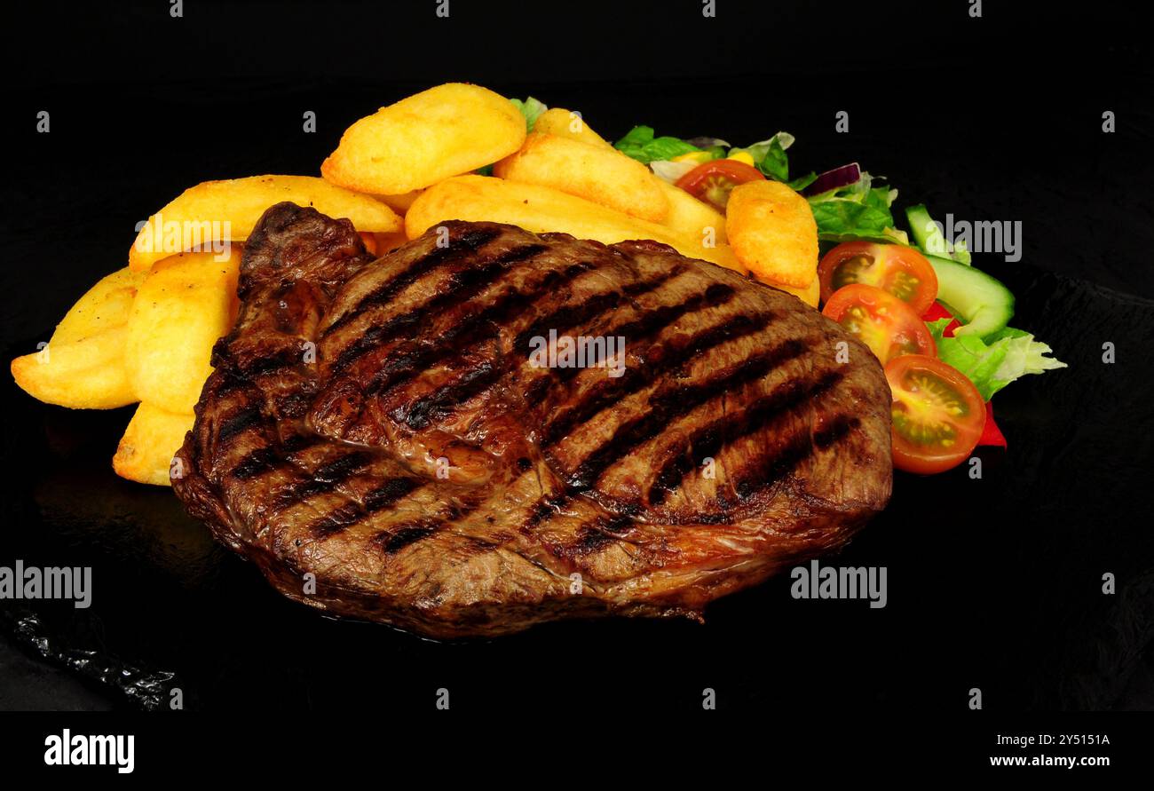 Grilled rib eye beef steak meal with chunky chips and salad Stock Photo ...