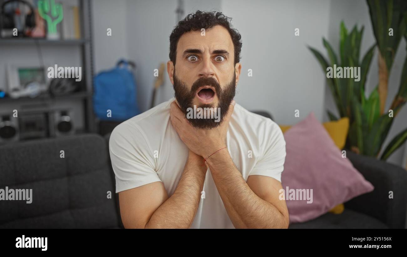 A shocked bearded man in a white shirt grasping his neck in a modern ...