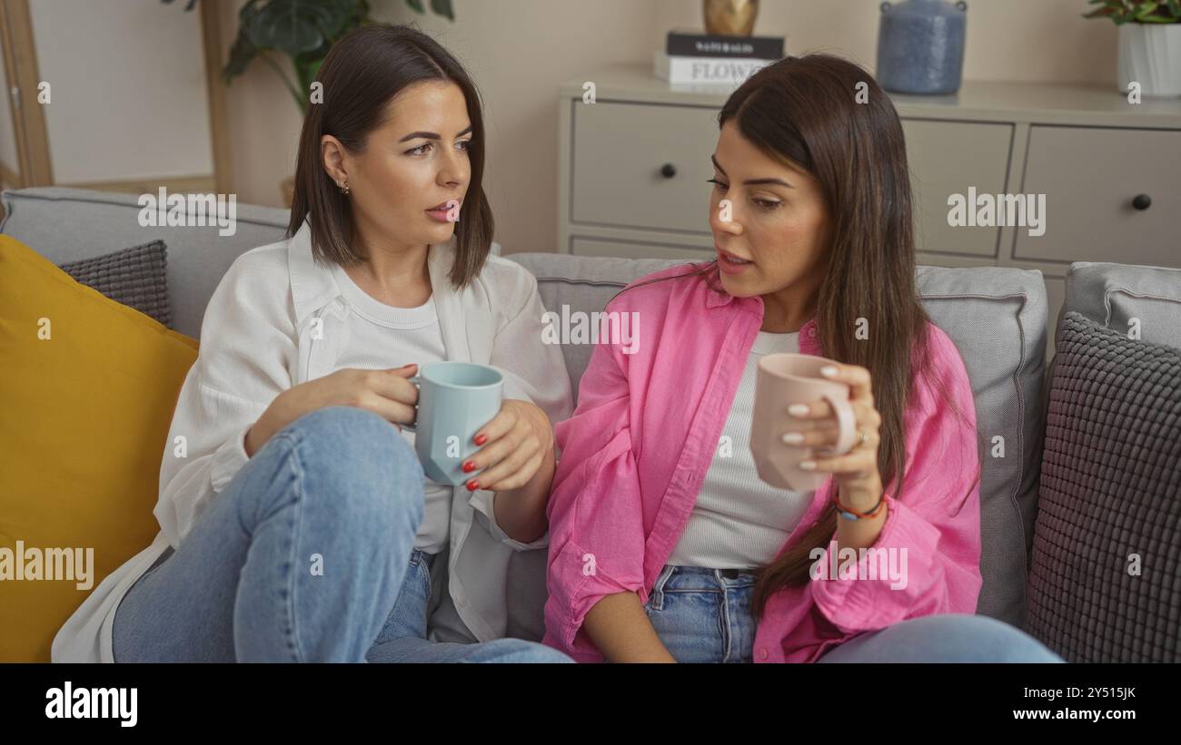 Two women enjoy coffee together in a cozy living room, engaging in a ...