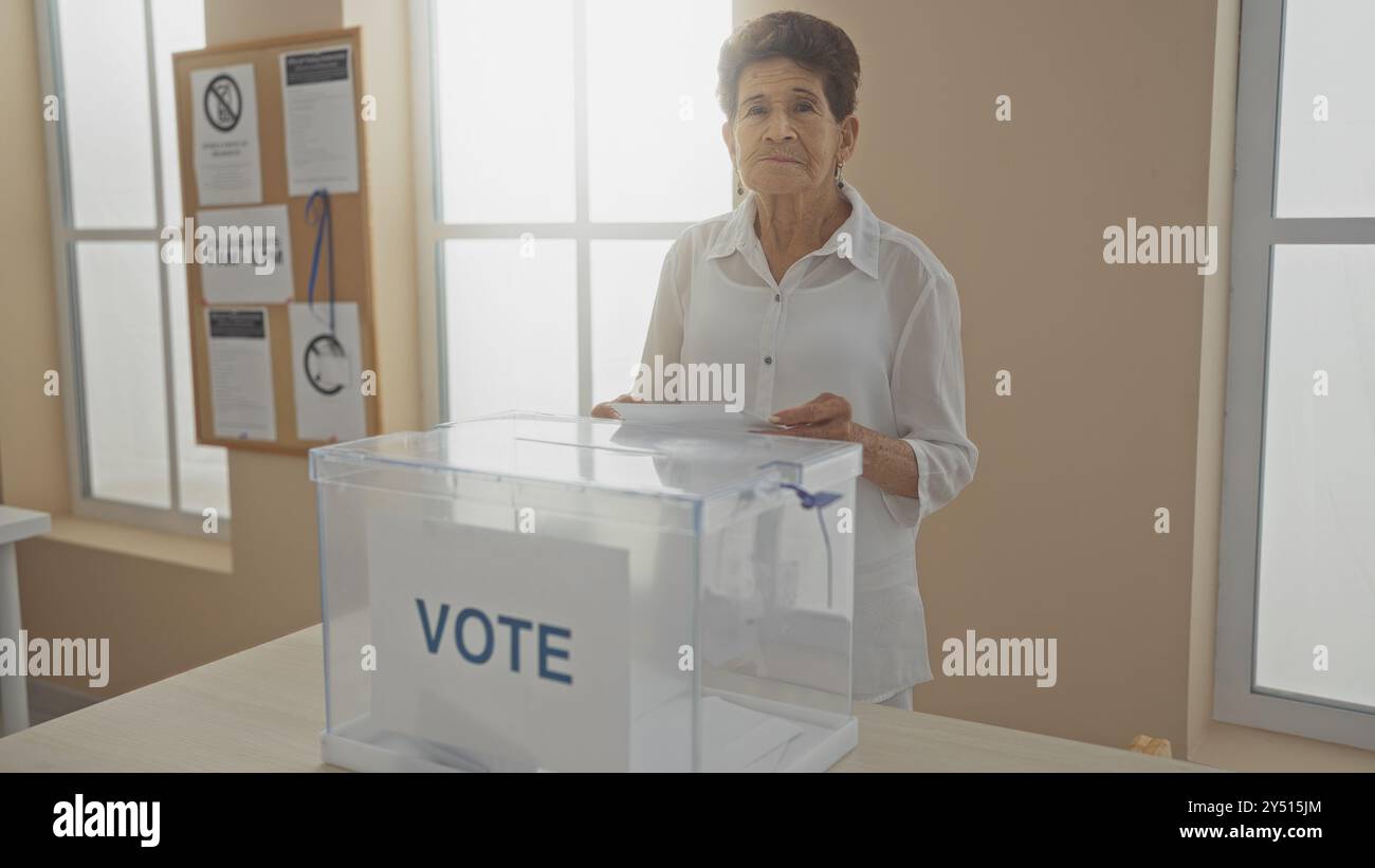 Elderly hispanic woman voting in an indoor electoral college room ...