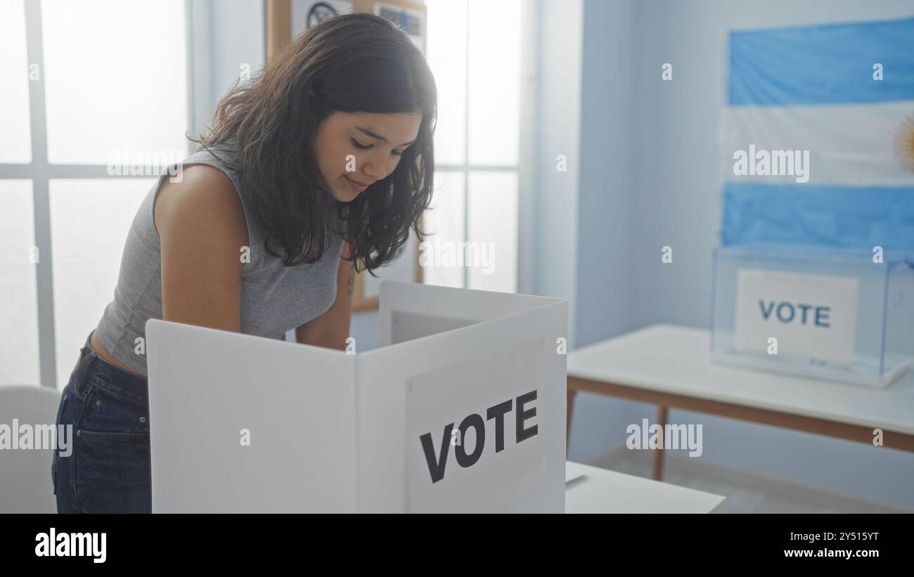 A young hispanic brunette woman casts her vote in an argentine ...