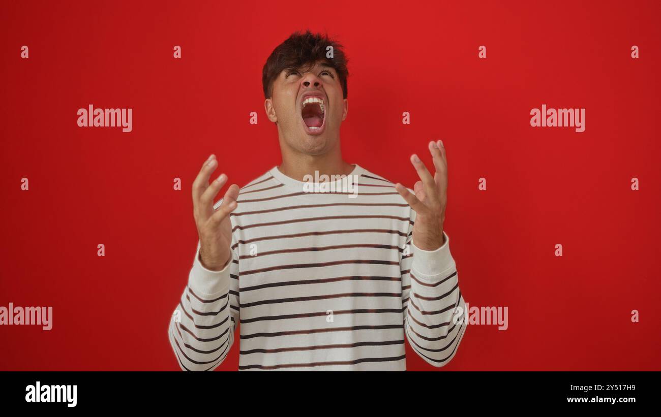 Frustrated young hispanic man screams while looking up, isolated ...