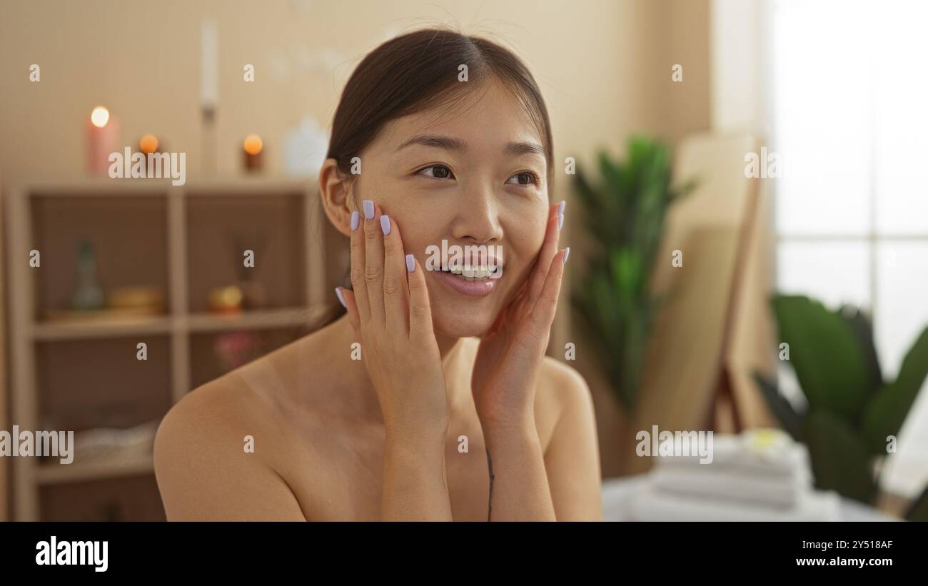 Beautiful chinese woman applying cream on face inside spa wellness ...
