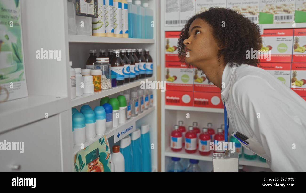 A young african american woman with curly hair examines shelves of ...