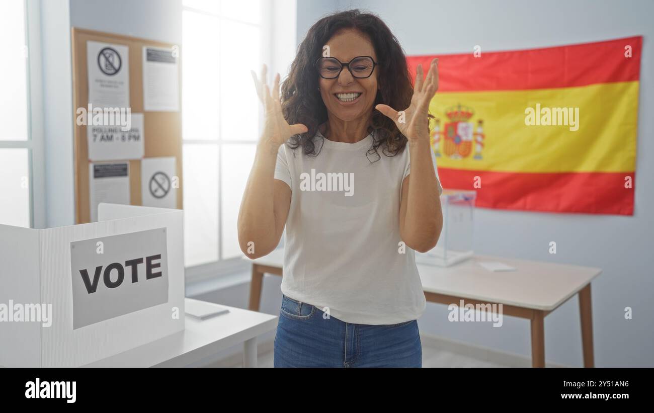 Woman voting in an indoor electoral room with a spain flag, expressing ...