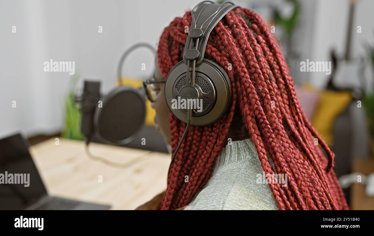 African american woman with braids wearing headphones in a music studio ...