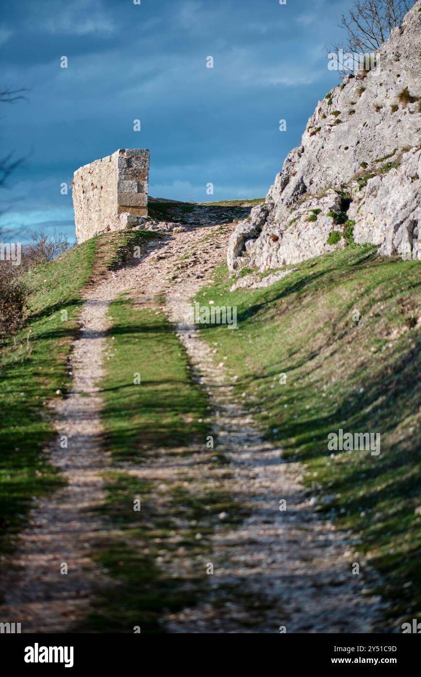 Stone structure on dirt path leading uphill with rocky terrain Stock ...