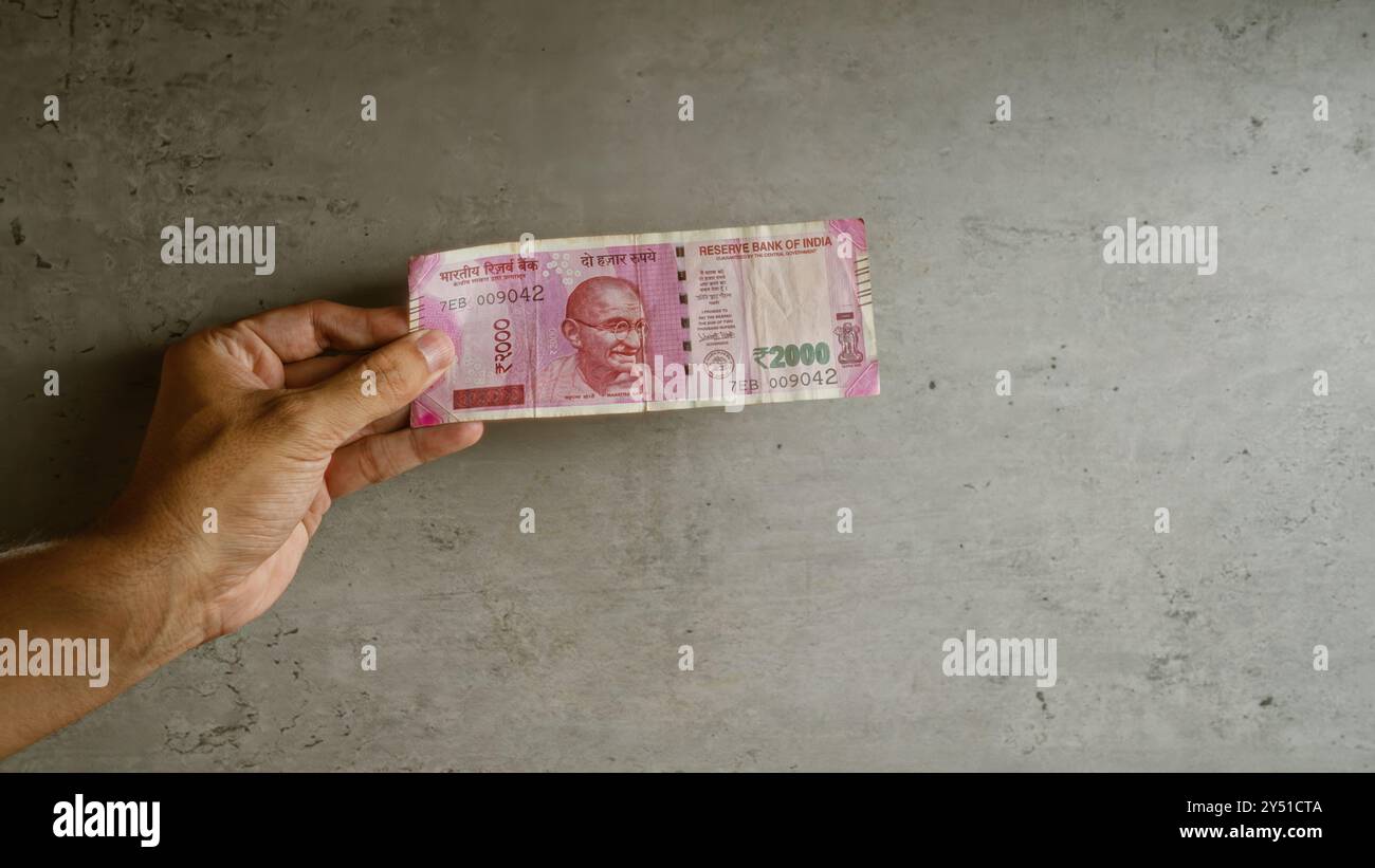 Hand holding indian 2000 rupee note against a concrete background Stock ...