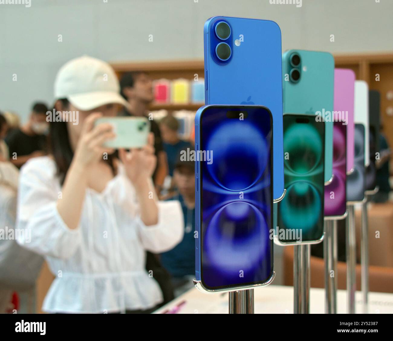 Customers takes photos the New Apple iPhone 16 series during the launch ...