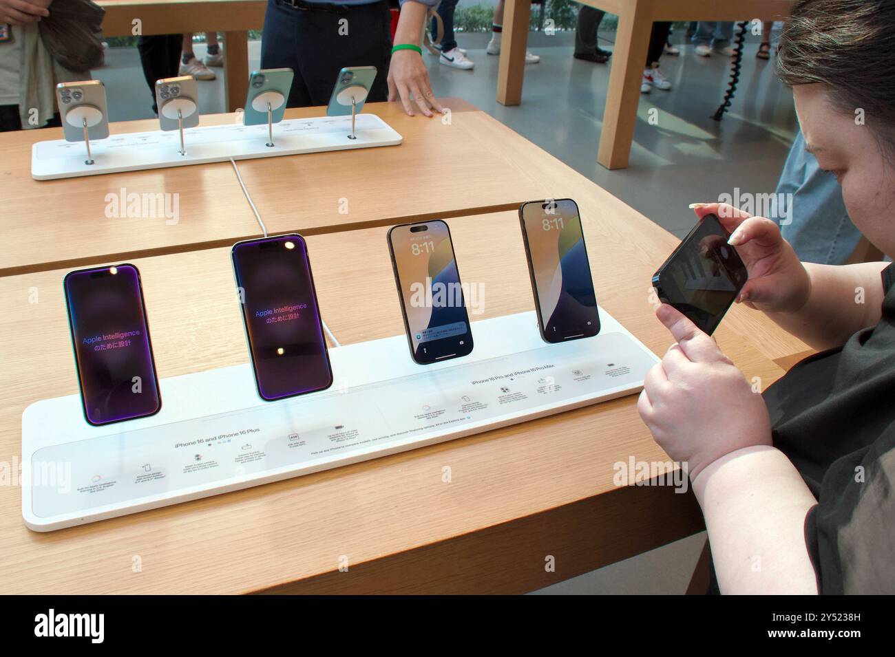 Customers takes photos the New Apple iPhone 16 pro series during the ...