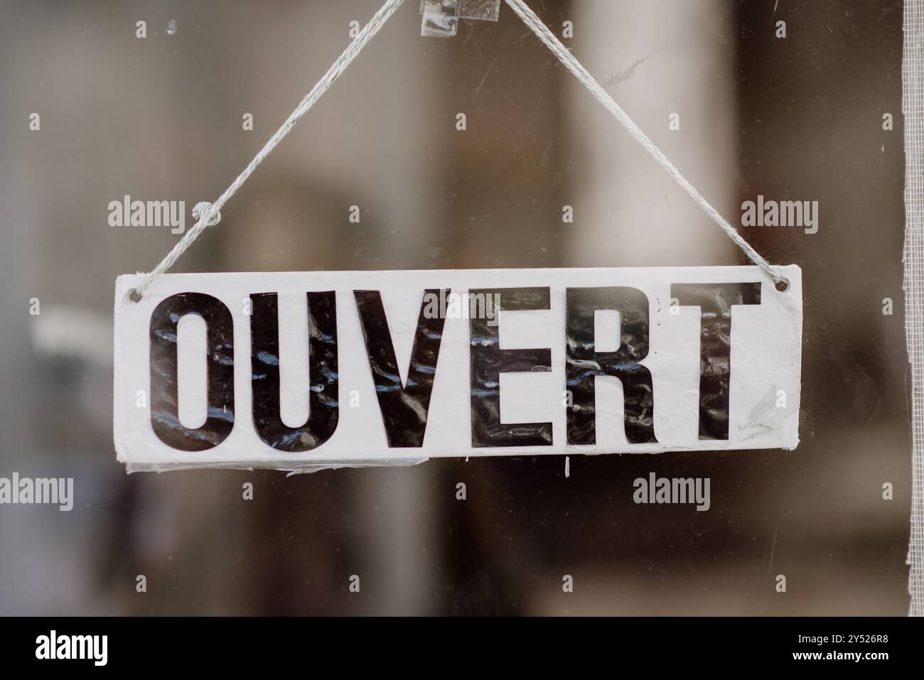 French 'ouvert' open sign displayed through a window Stock Photo - Alamy