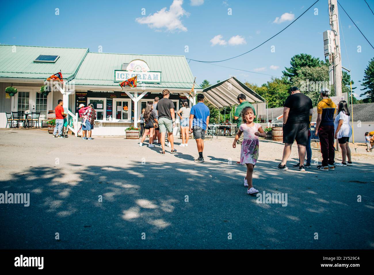 girl walking towards the camera, with group of people standing in line ...