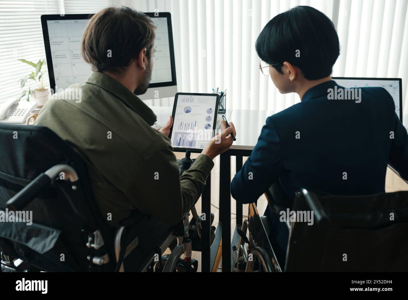 Colleagues With Disability Examining Graphics Stock Photo - Alamy