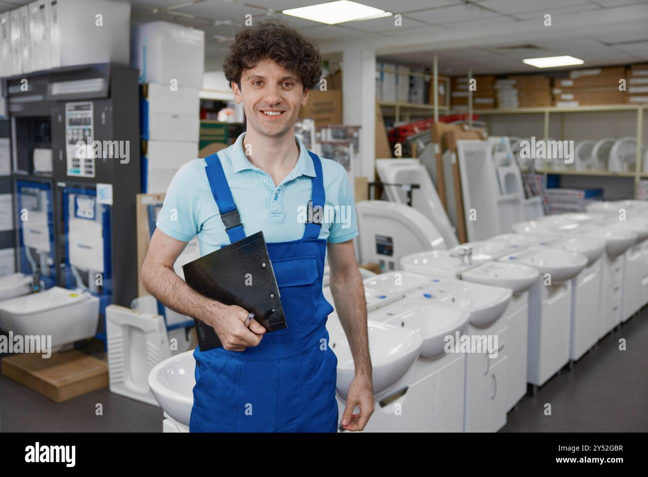 Portrait of friendly smiling salesman at plumbing retail store Stock ...