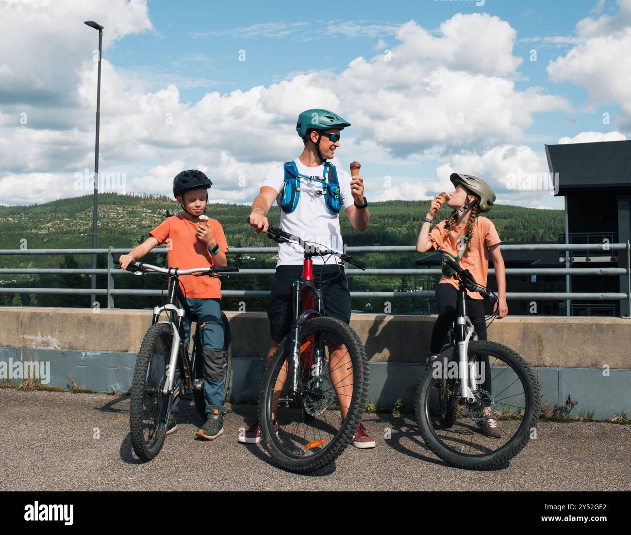 father & two children eating ice cream whilst on a bike ride in Norway ...