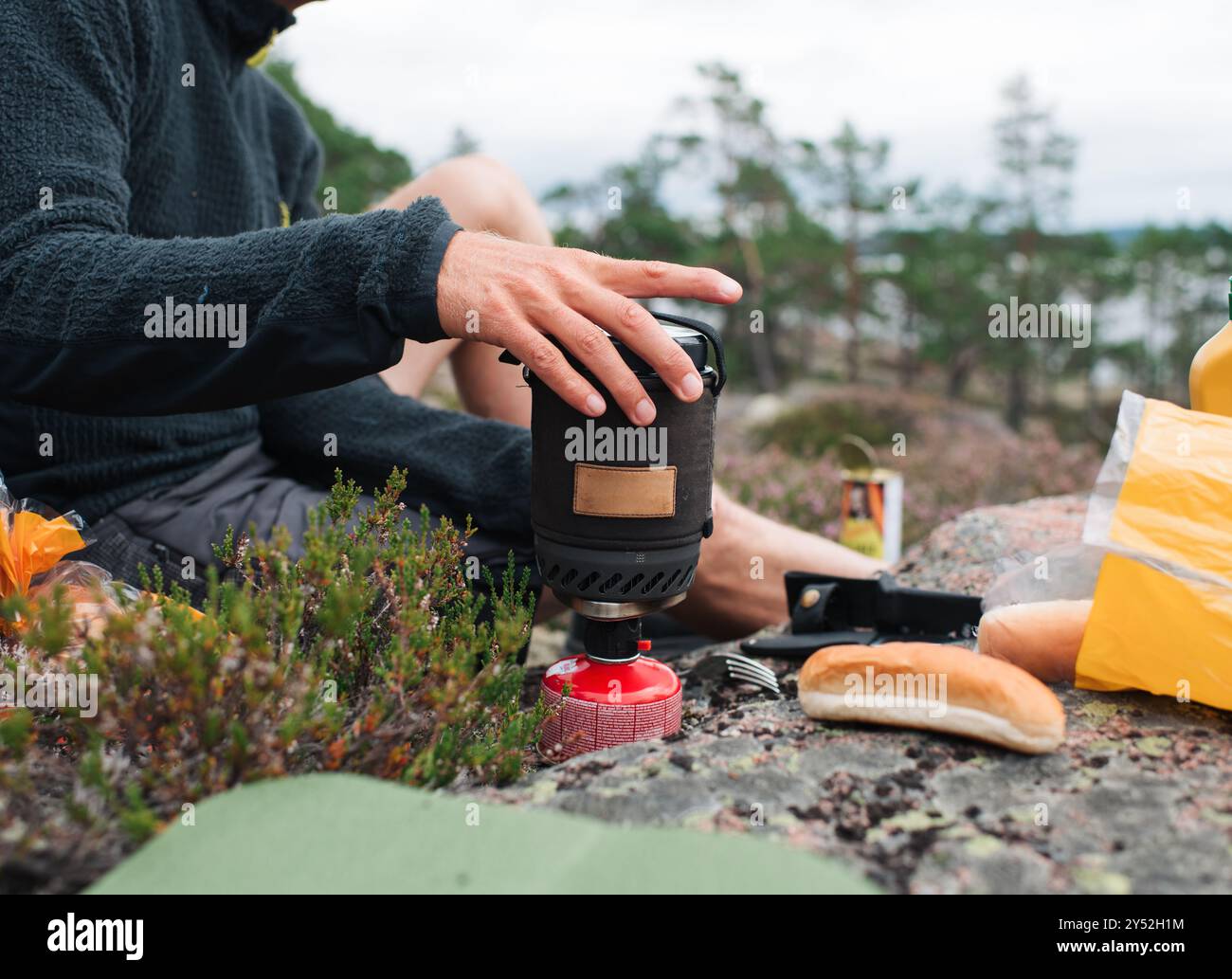 man boiling water on an outdoor cooker in the Swedish high coast Stock ...