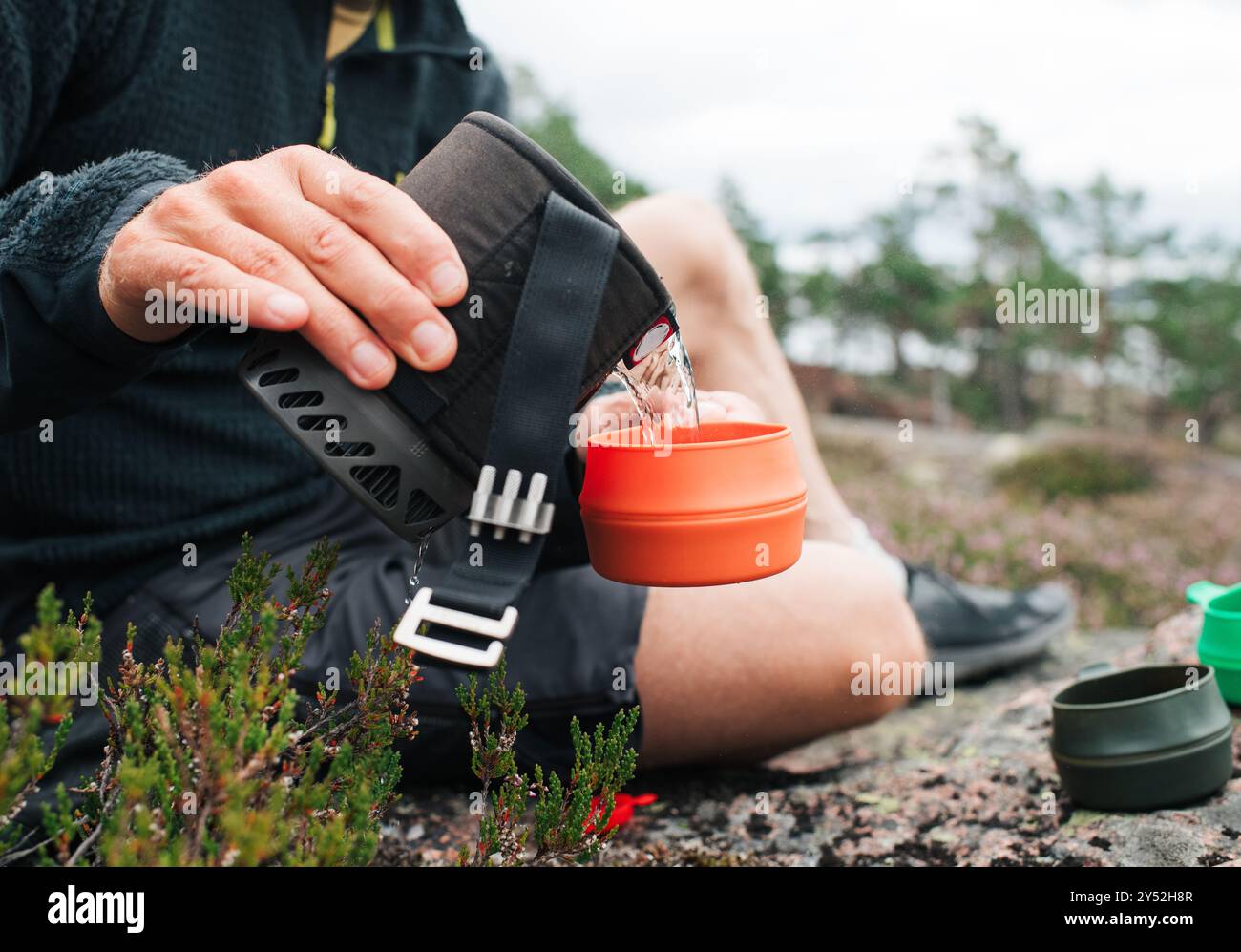 man pouring boiling water in a mug for coffee outdoors Stock Photo - Alamy