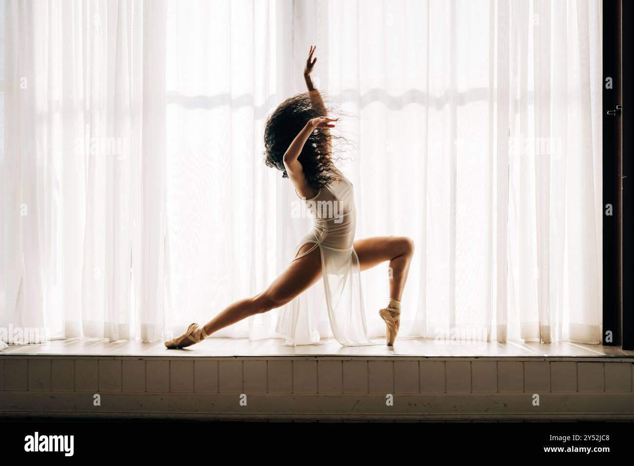 Ballet dancer in a strong pose, backlit by soft natural light Stock ...