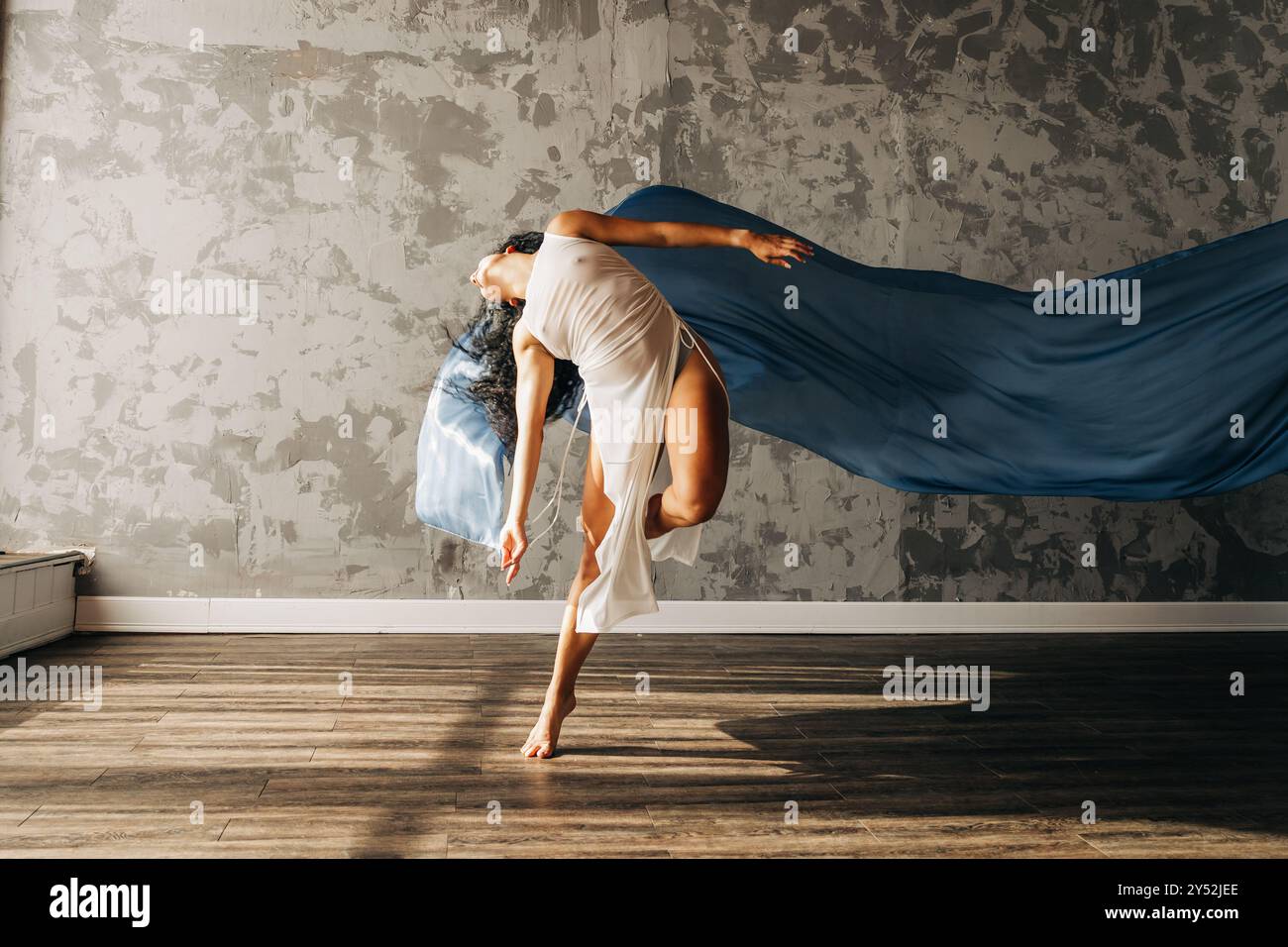 Ballet dancer with flowing blue fabric, gracefully arching Stock Photo ...