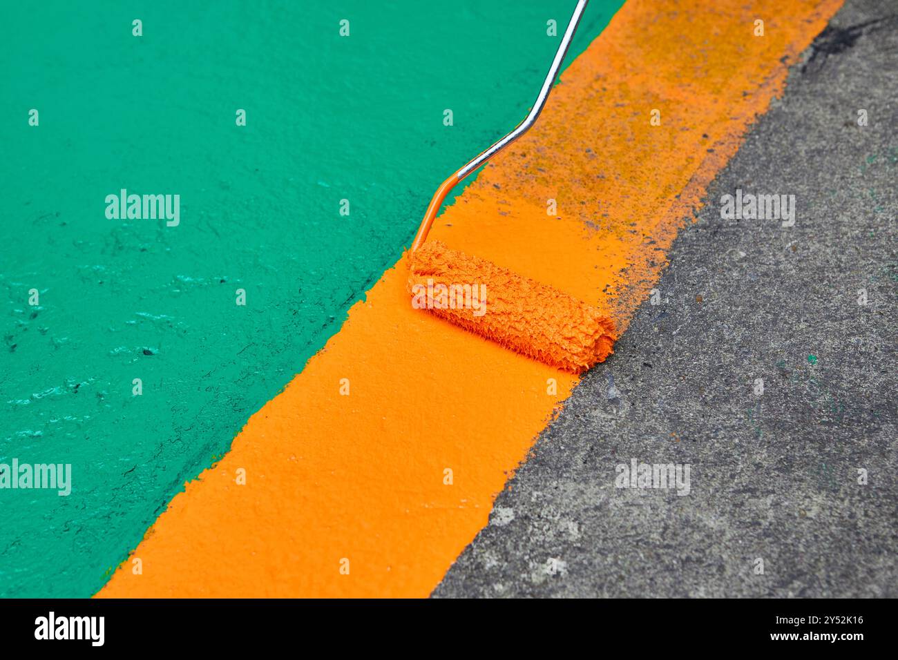 Paint roller and painting green and yellow color on footpath Stock ...