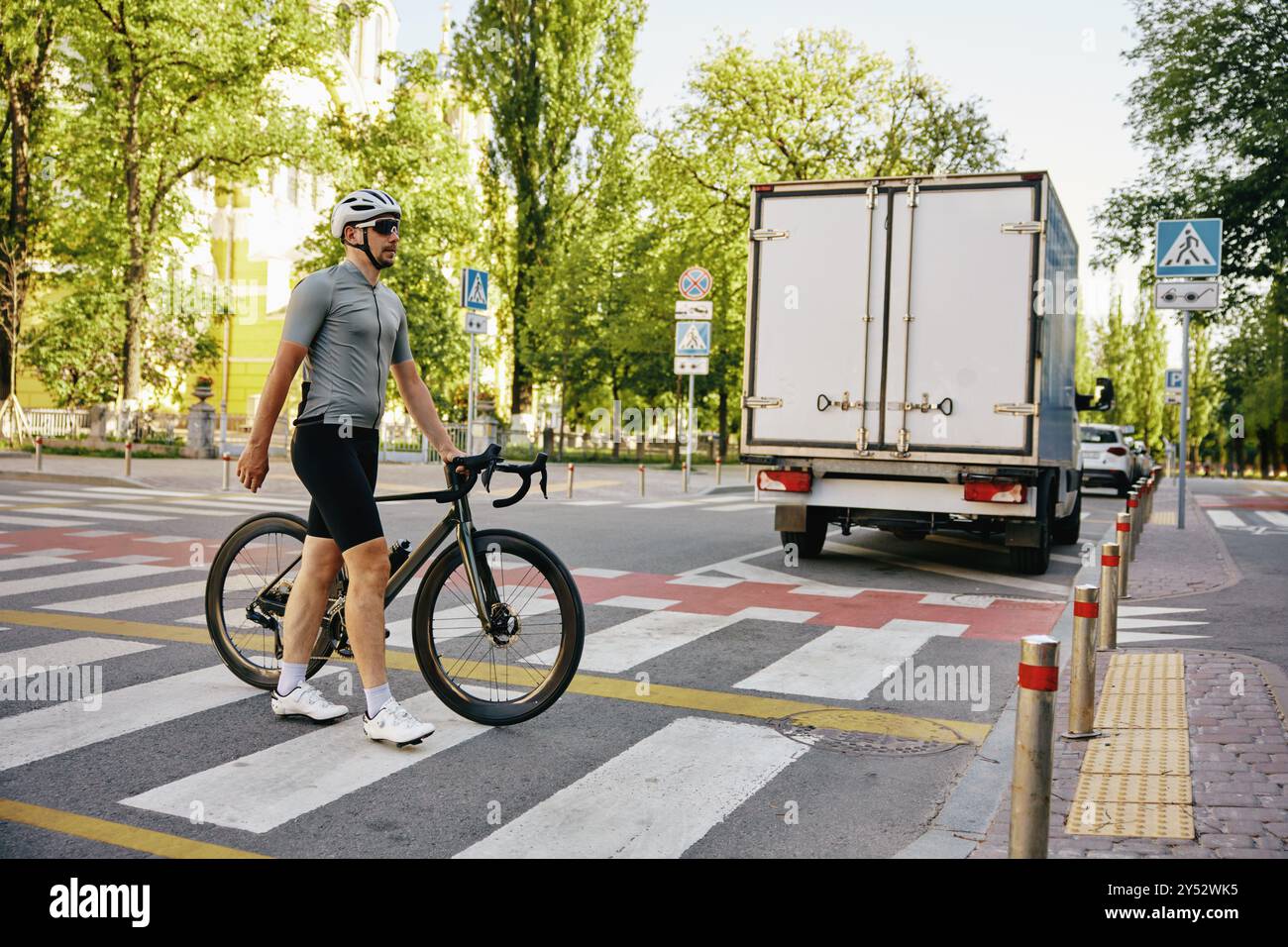 Man cyclist crossing city road using pedestrian in compliance with ...