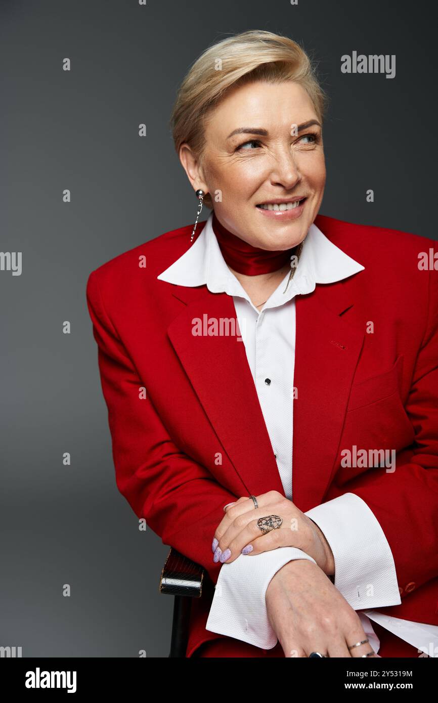 An adult woman dressed in red showcases elegance and poise, smiling ...