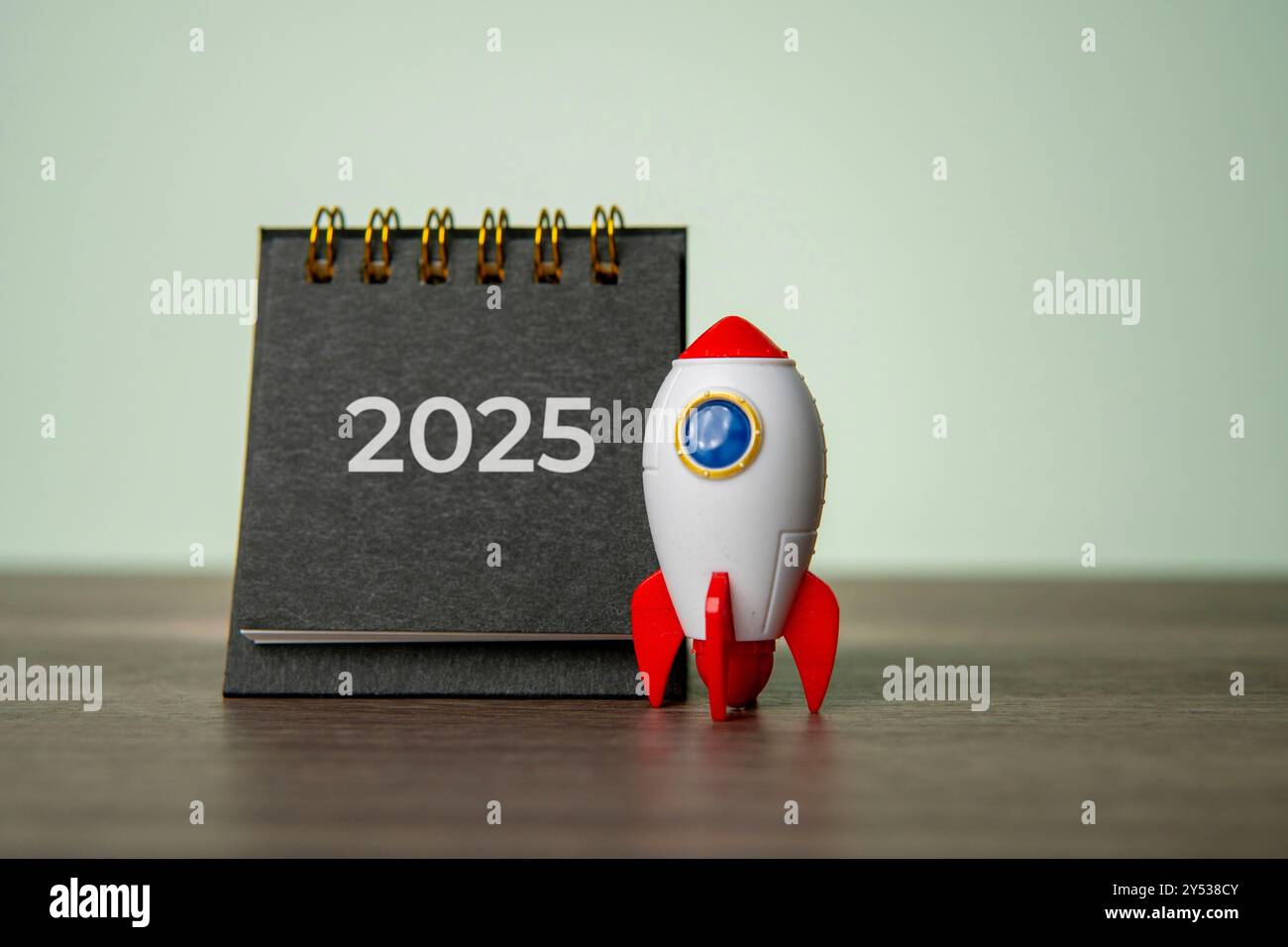 A small model rocket placed next to a 2025 flip calendar. Business ...