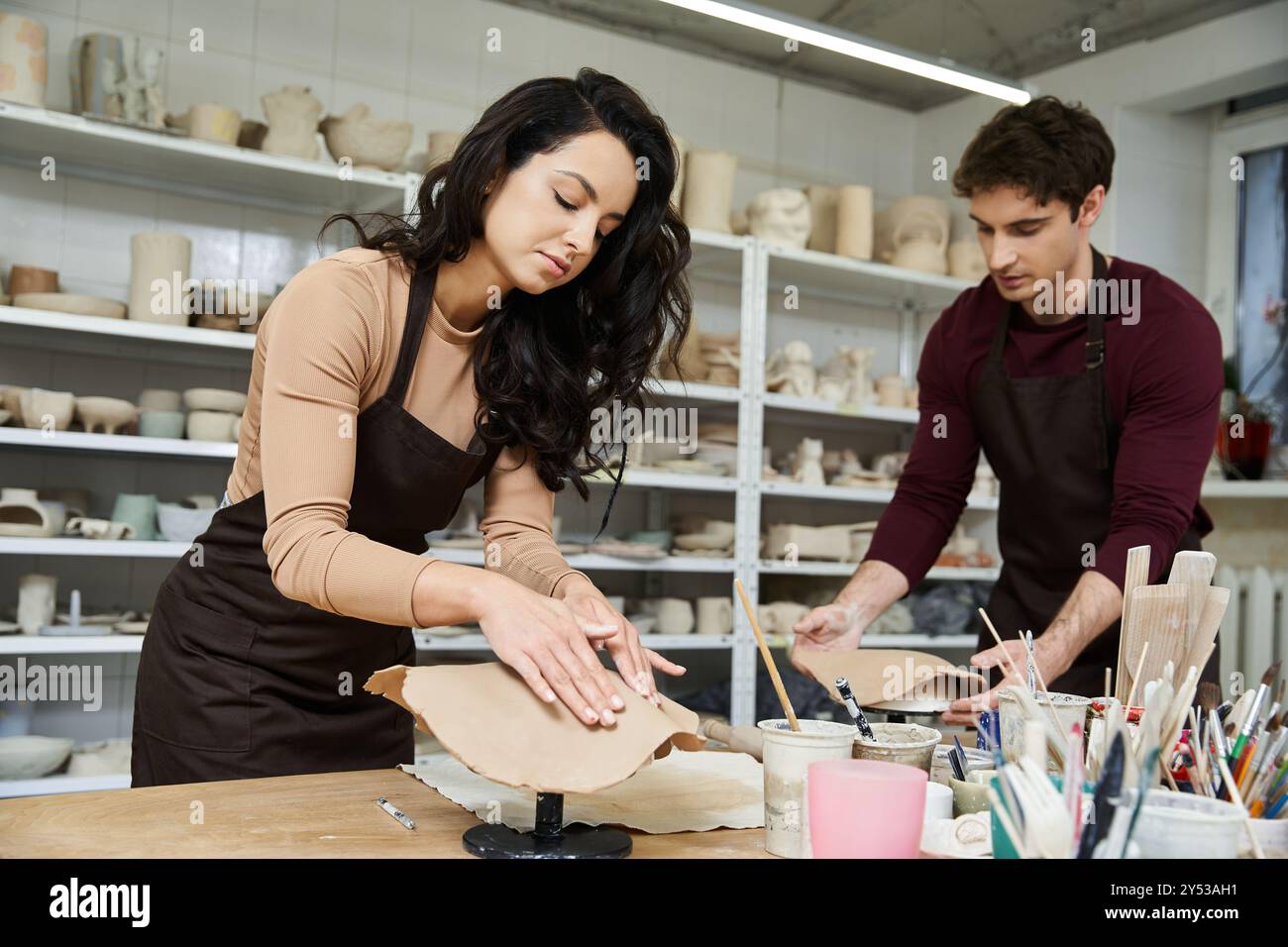A couple enjoys crafting pottery together in a contemporary studio ...