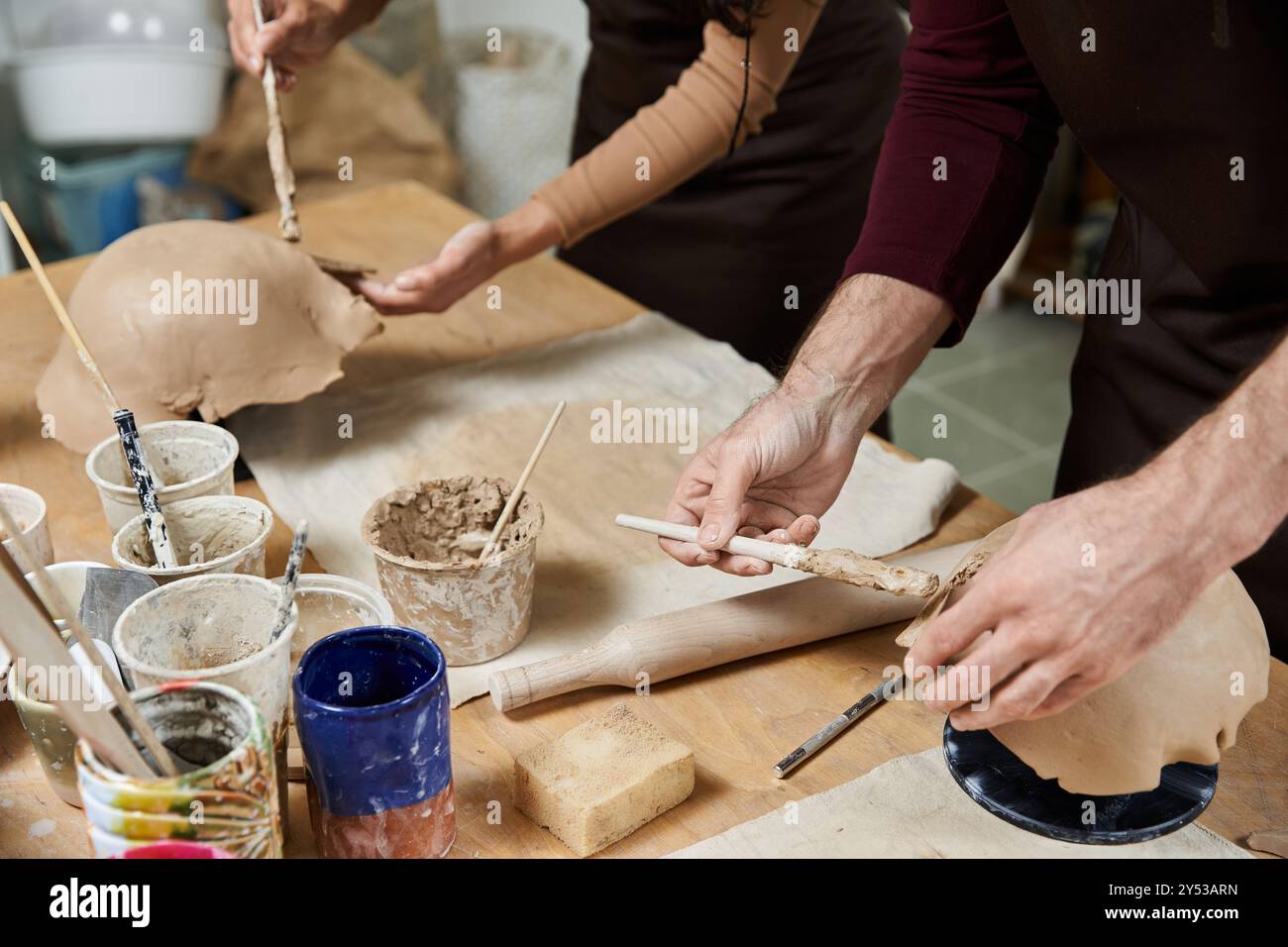 Two artists mold clay as they enjoy a creative moment in their studio ...