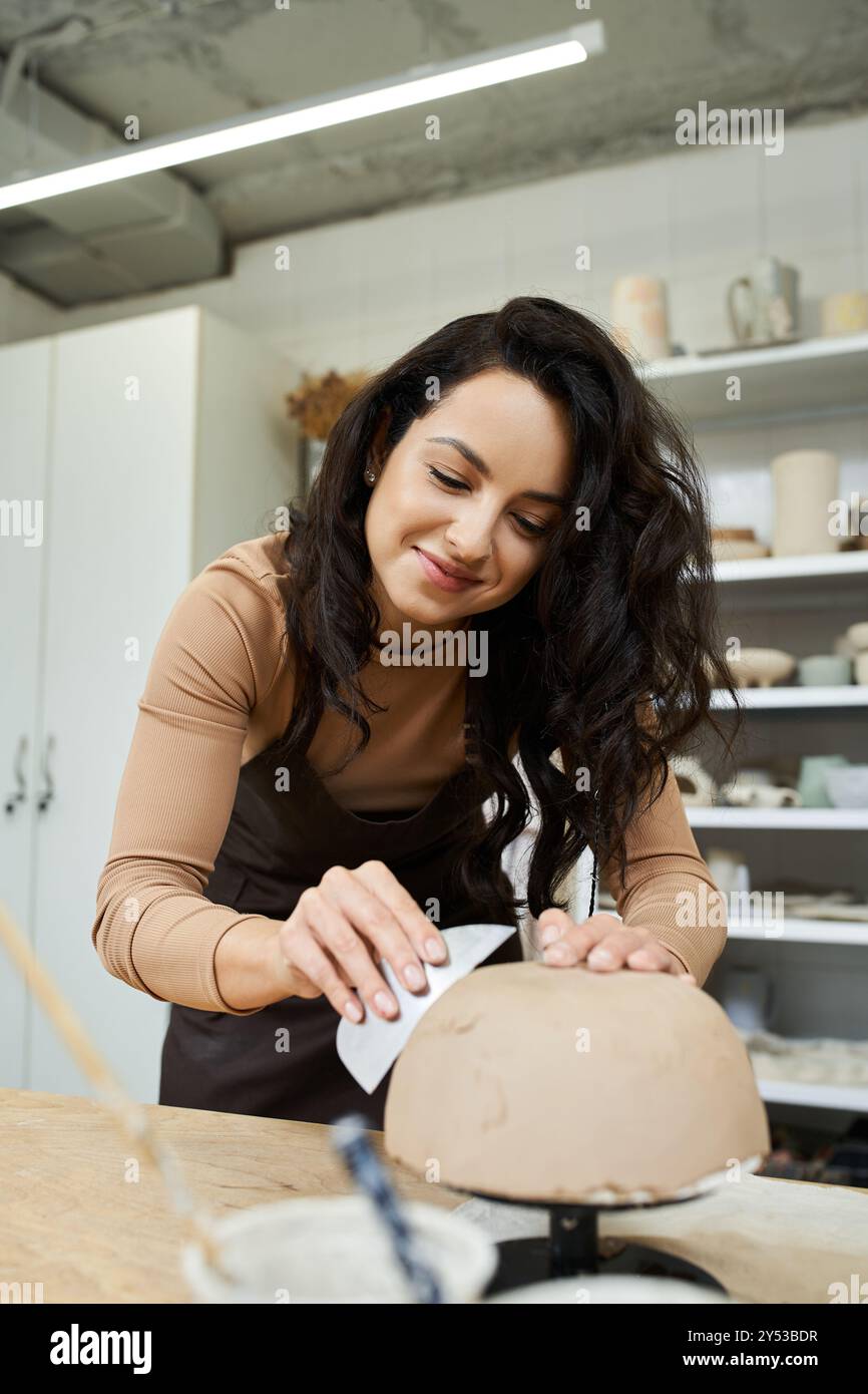 Jolly good looking woman with dark hair making pottery Stock Photo - Alamy