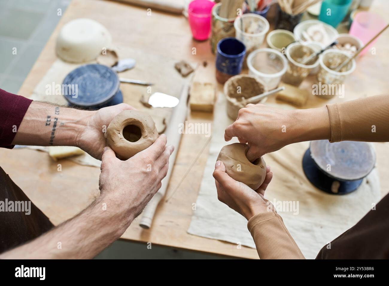 A couple joyfully molds clay into art in their vibrant pottery studio ...