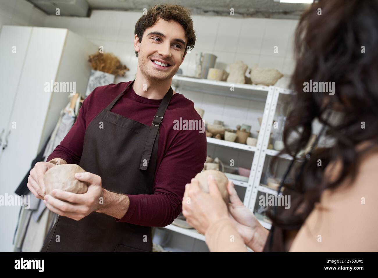 A couple joyfully shapes clay in a contemporary pottery studio Stock ...