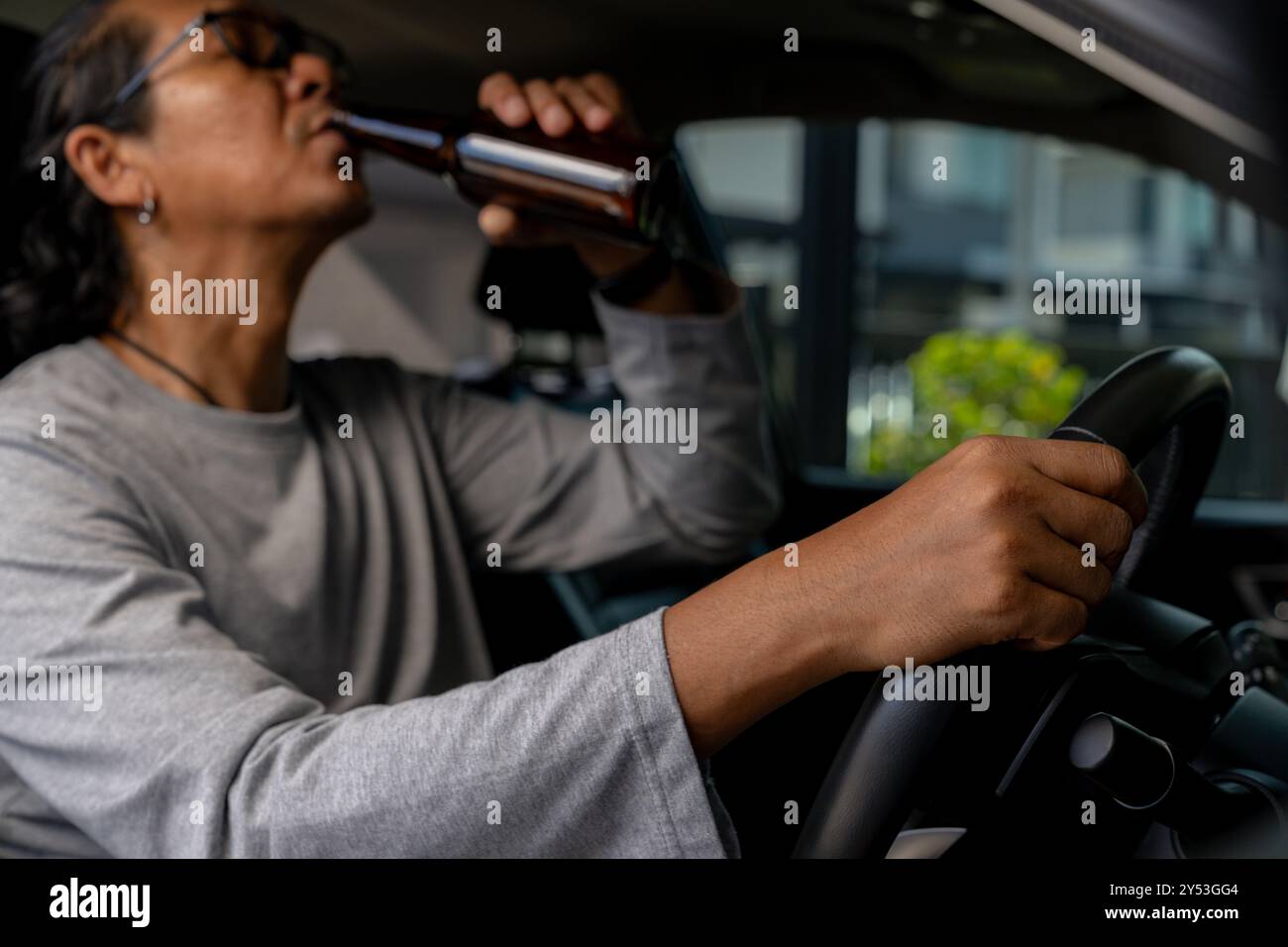 Male holding bottle beer driving hi-res stock photography and images ...