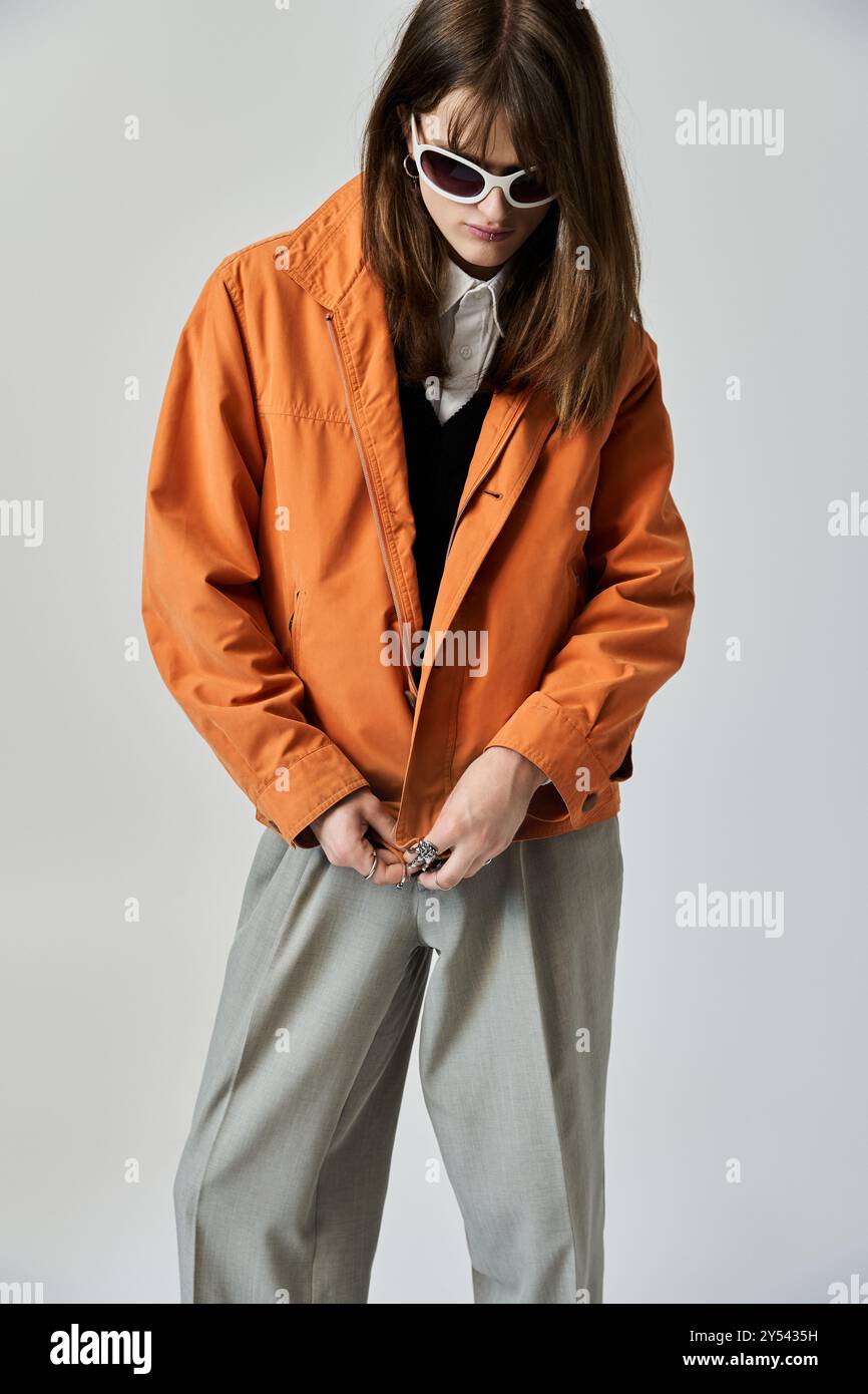 A young person dressed in trendy attire confidently poses with flair ...