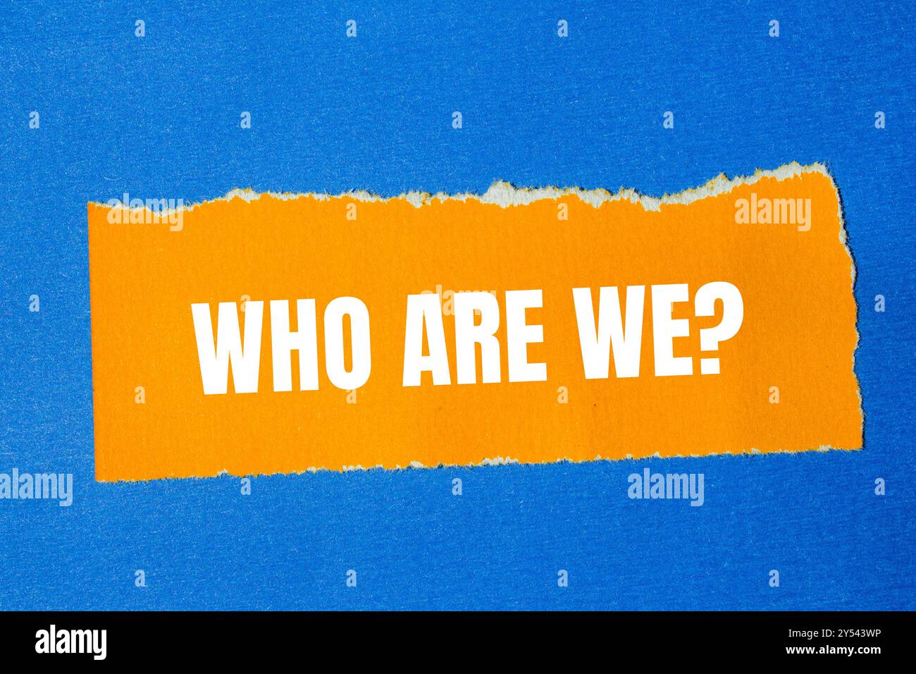 Who are we question message written on ripped torn orange paper with ...