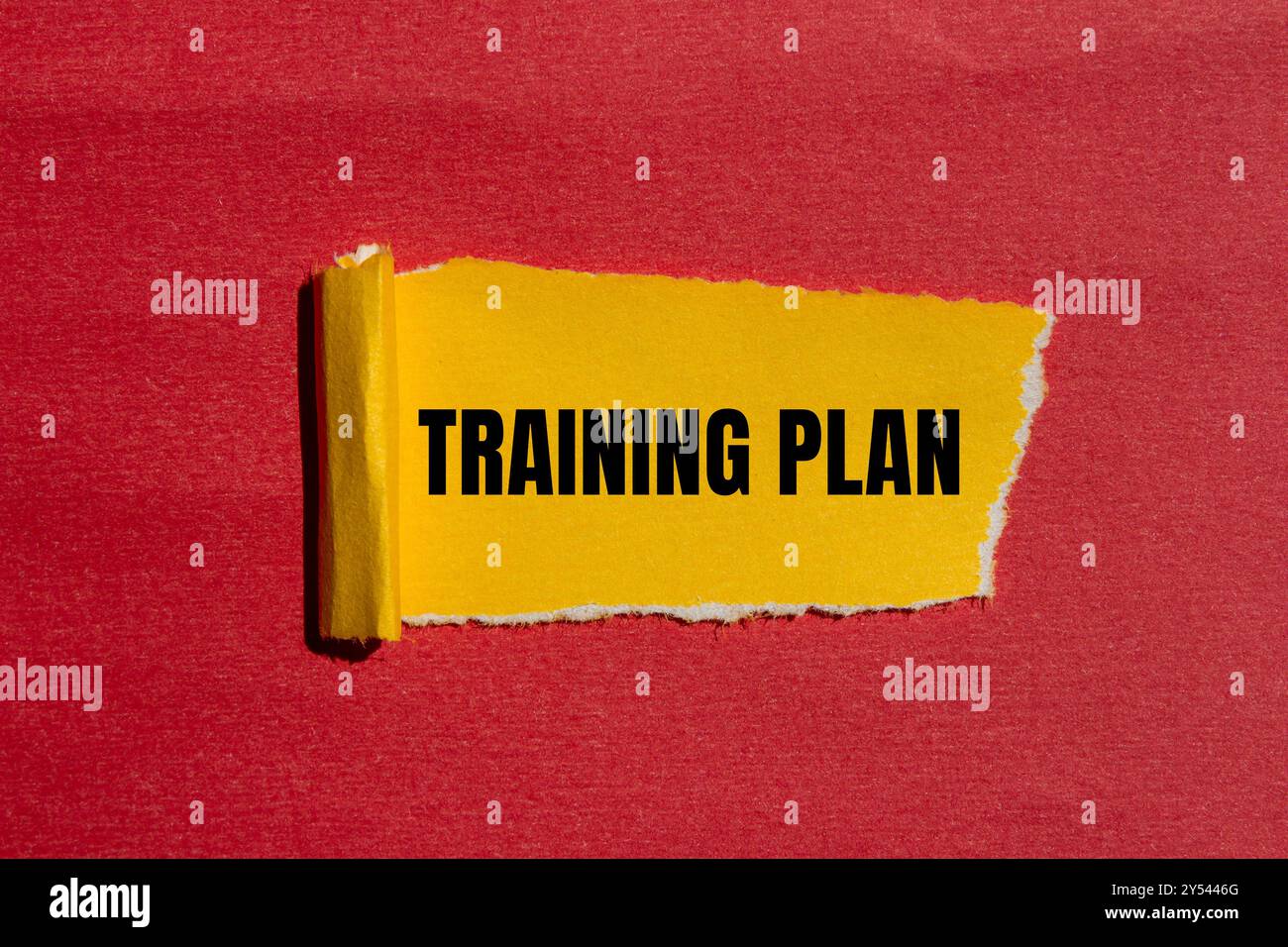 Training plan message written on ripped torn yellow paper with red ...