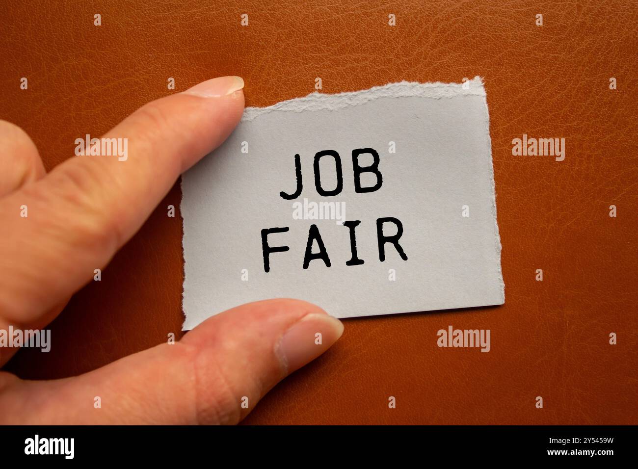 Job fair message written on ripped torn paper piece on brown background ...