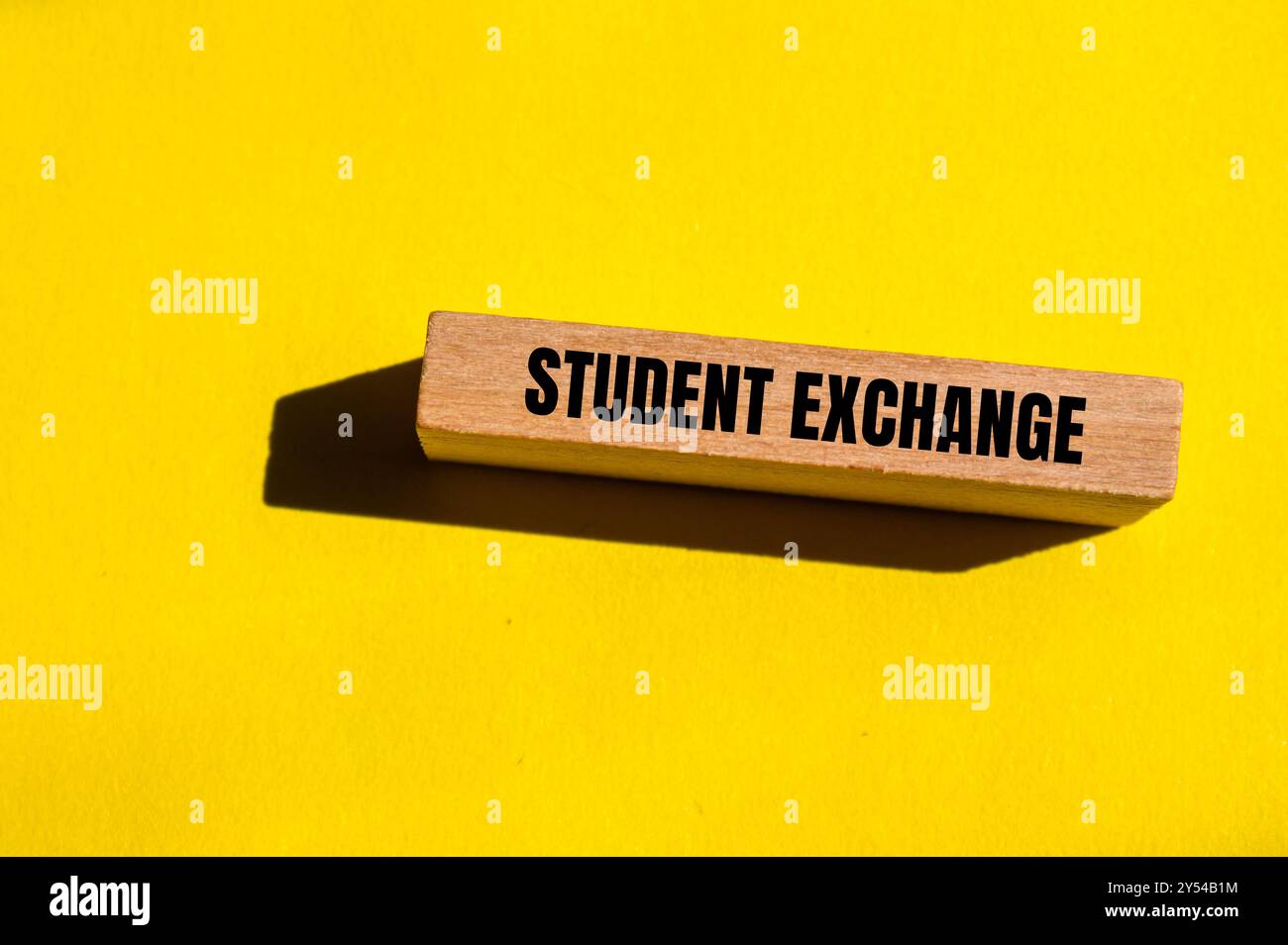 Student exchange message written on wooden block with yellow background ...