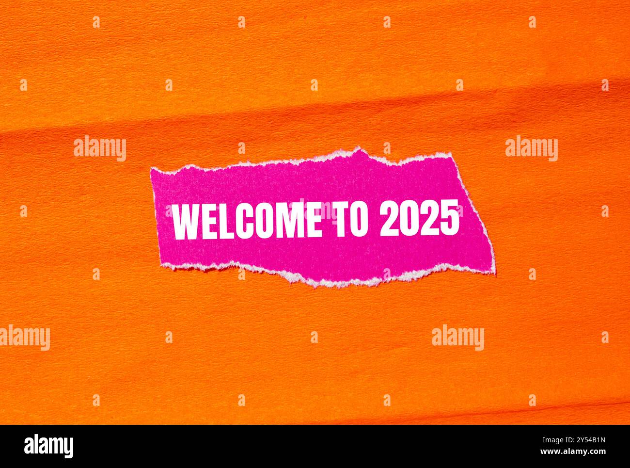 Welcome to 2025 message written on ripped torn pink paper with orange ...