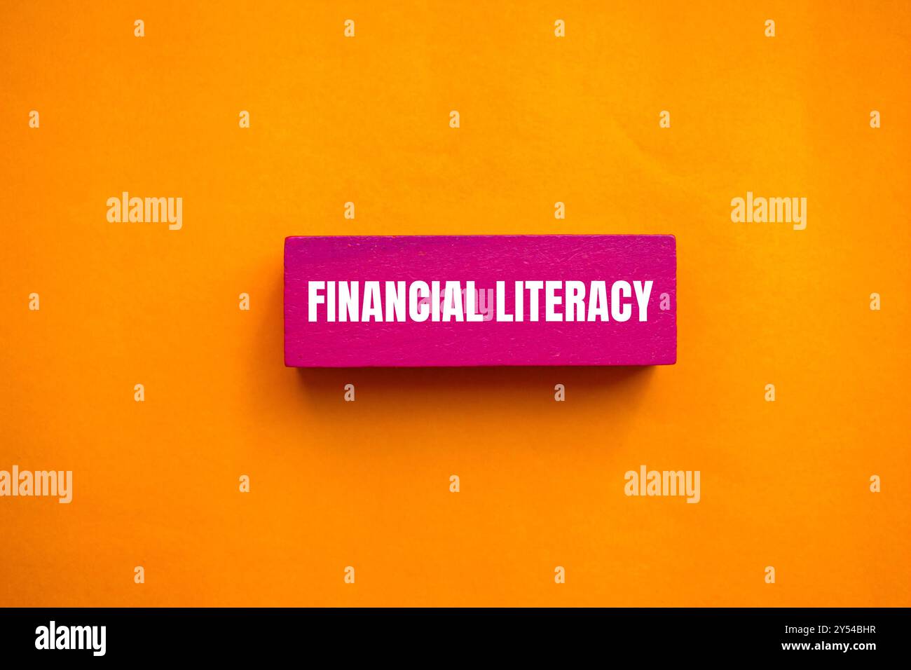 Financial literacy message written on pink wooden block with orange ...