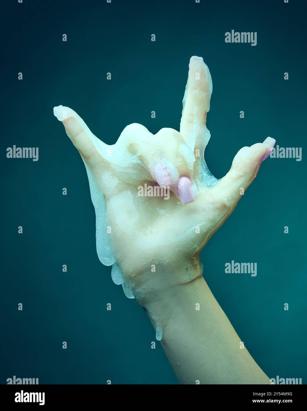 Female hand covered in slime, gesturing against cyan green background ...