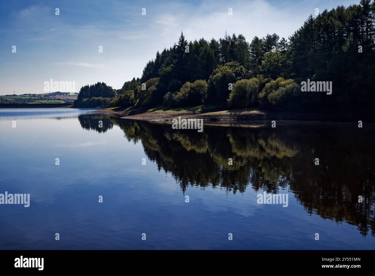 Woodland reflections in the still waters of Wayoh Reservoir, Blackburn ...